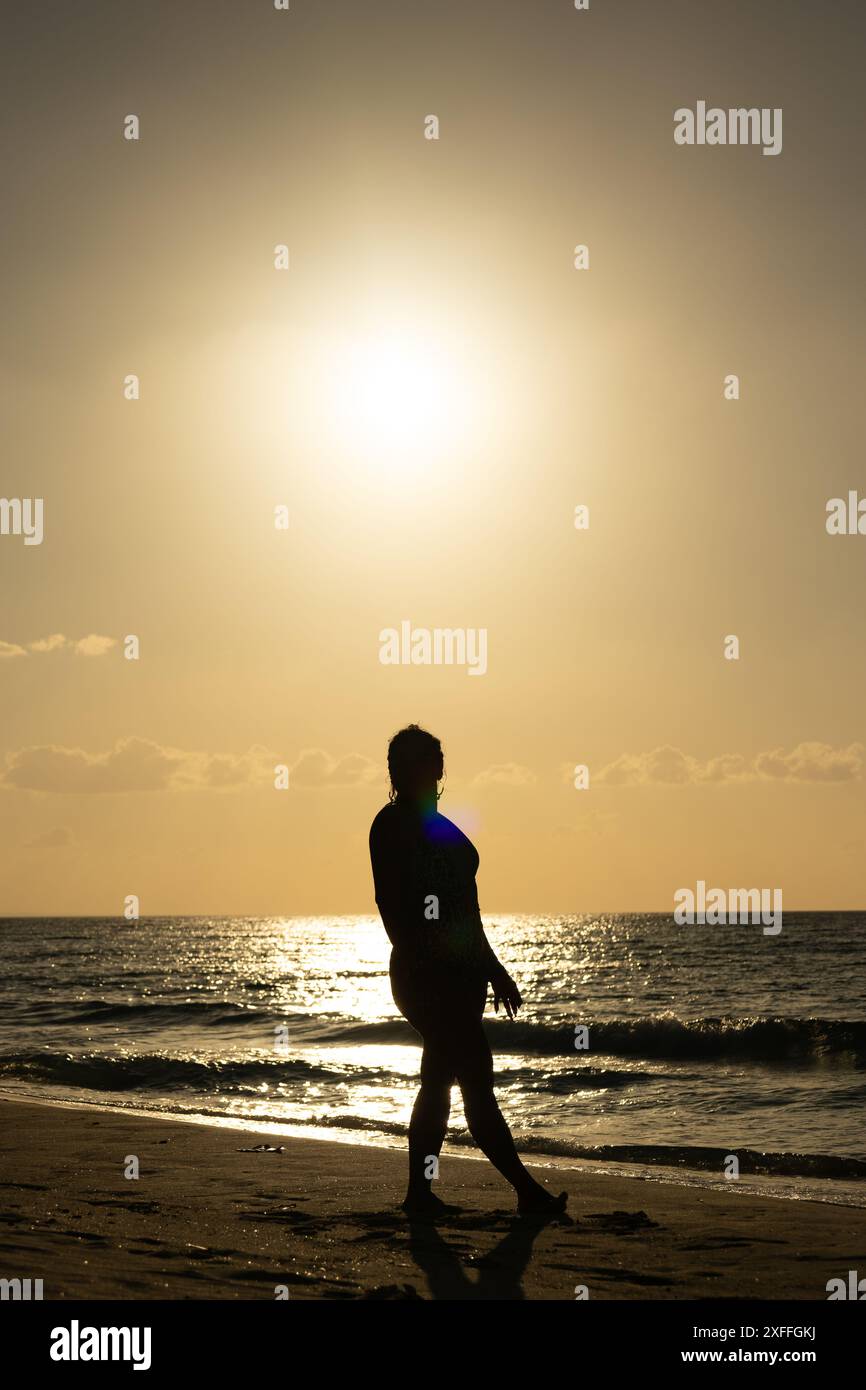 photo of muscular woman silhouette against light at sunset on the Cuban ...