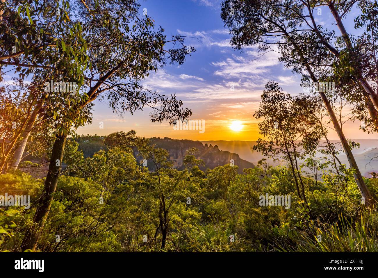 A breathtaking sunset casts a golden glow over the iconic Three Sisters ...