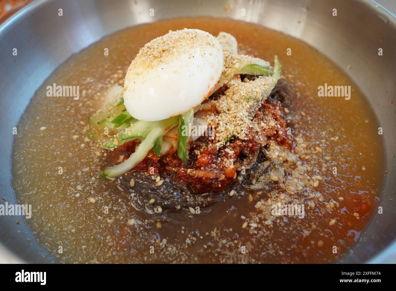 Naengmyeon is a unique Korean noodle dish made with cold broth topped ...