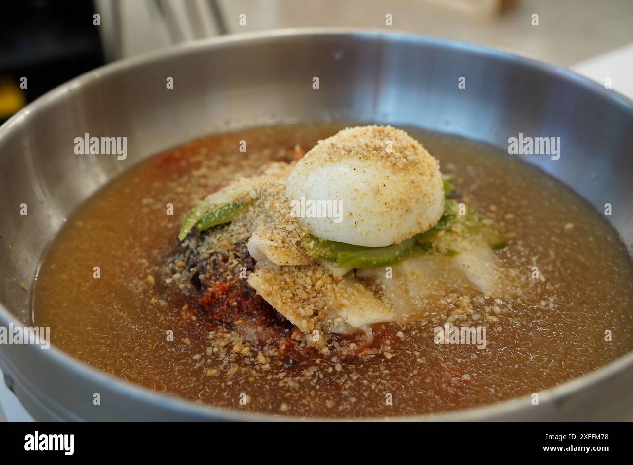 Naengmyeon is a unique Korean noodle dish made with cold broth topped ...