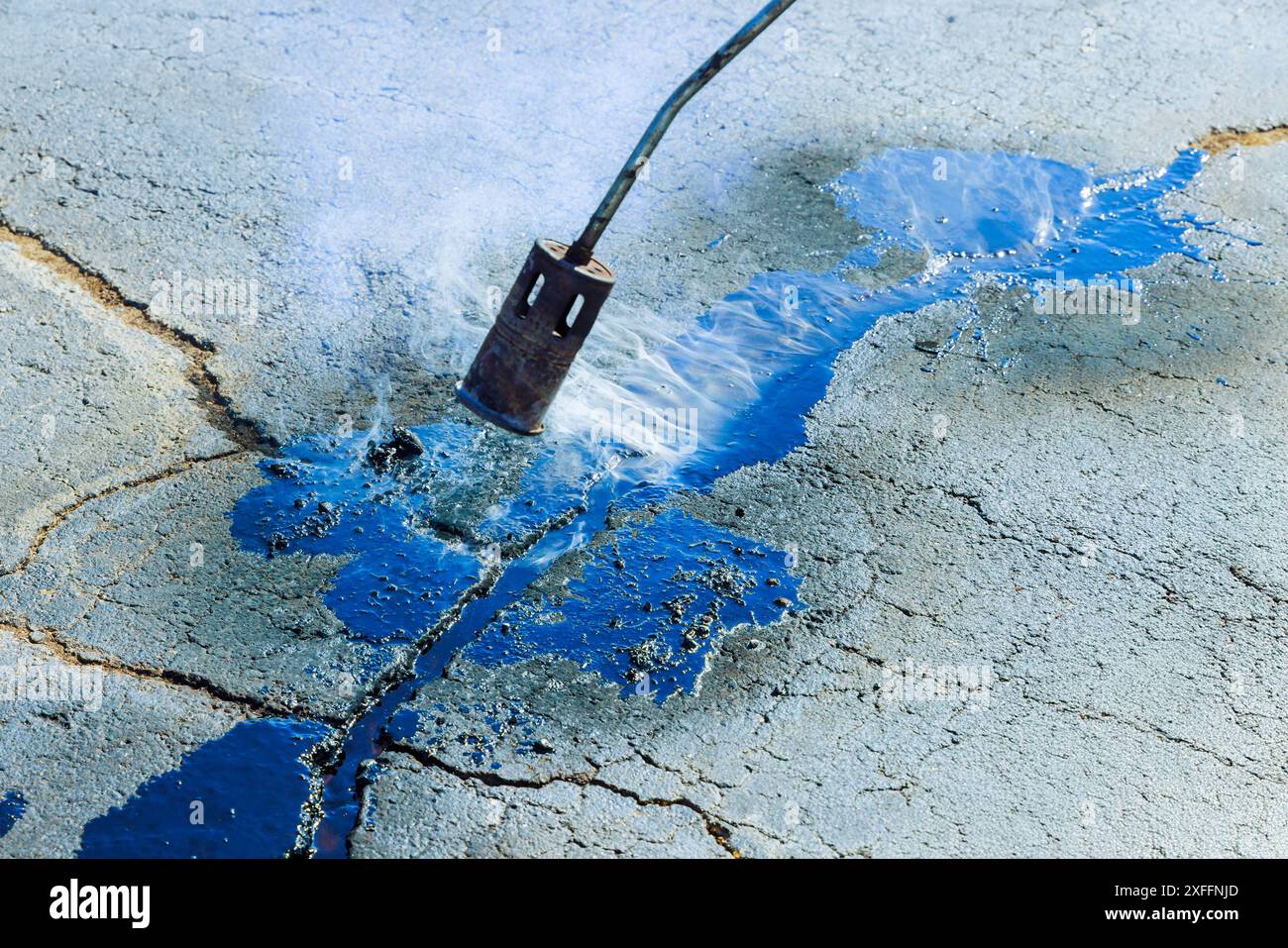 Heating cracks in asphalt before they are filled with hot bitumen ...