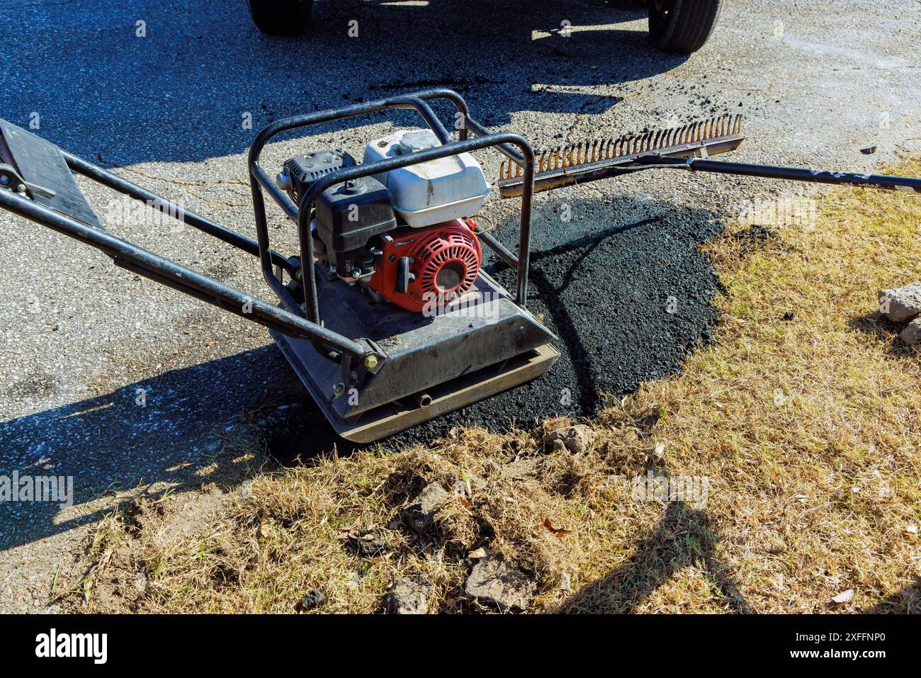 At parking lot repair, manual tamping of asphalt is performed using ...