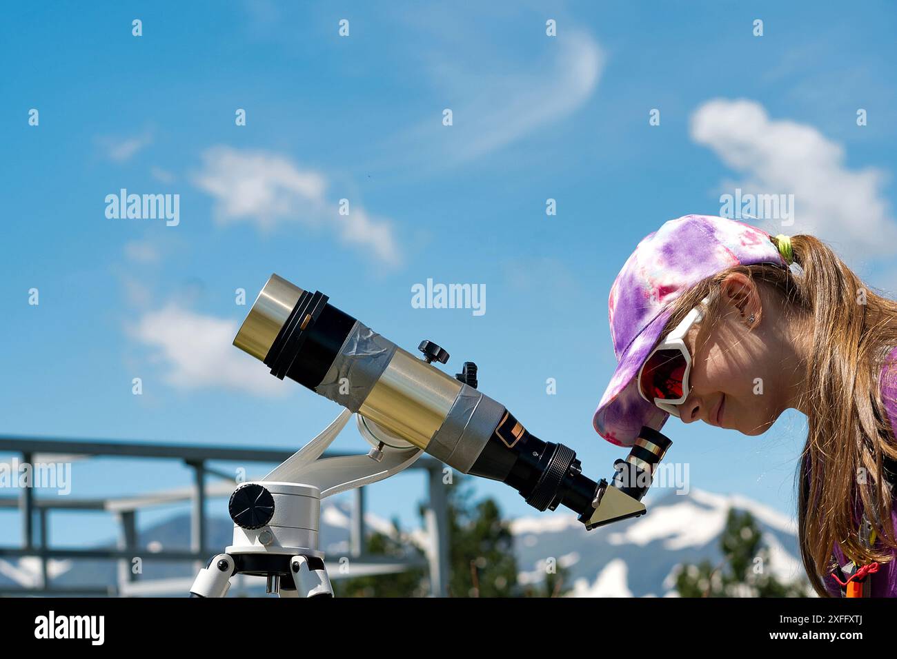 Girl observing through a solar telescope under a bright blue sky Stock ...