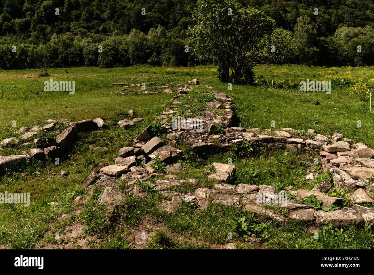 Ruins of an ancient structure in a lush green field. Solar Circle solar ...