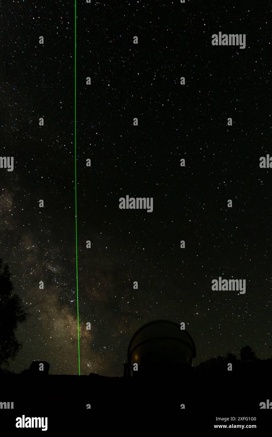 Green laser beam extending into the starry sky at night. Observatory ...