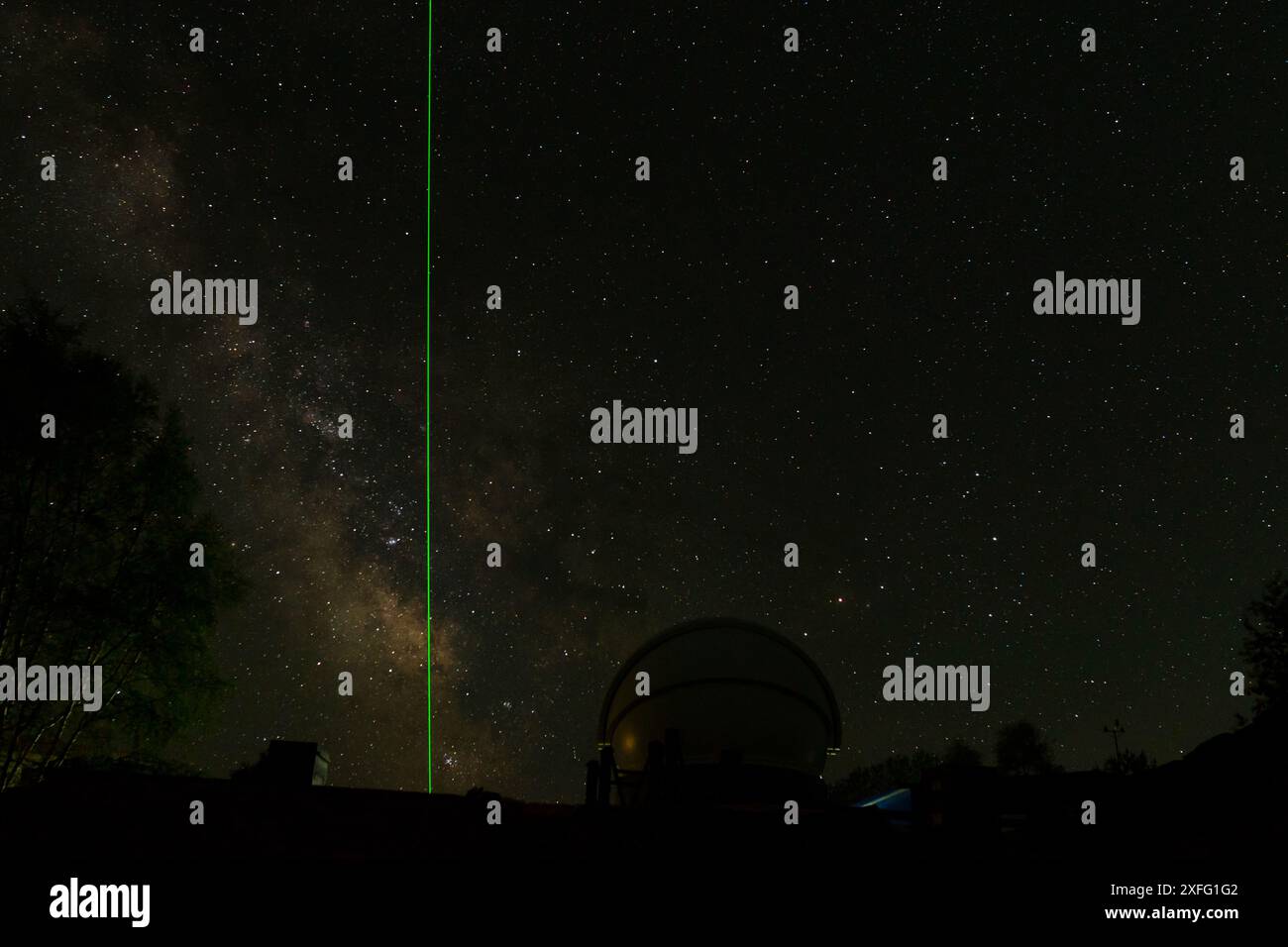 A green laser beam points to the Milky Way at night. Stellar night sky ...