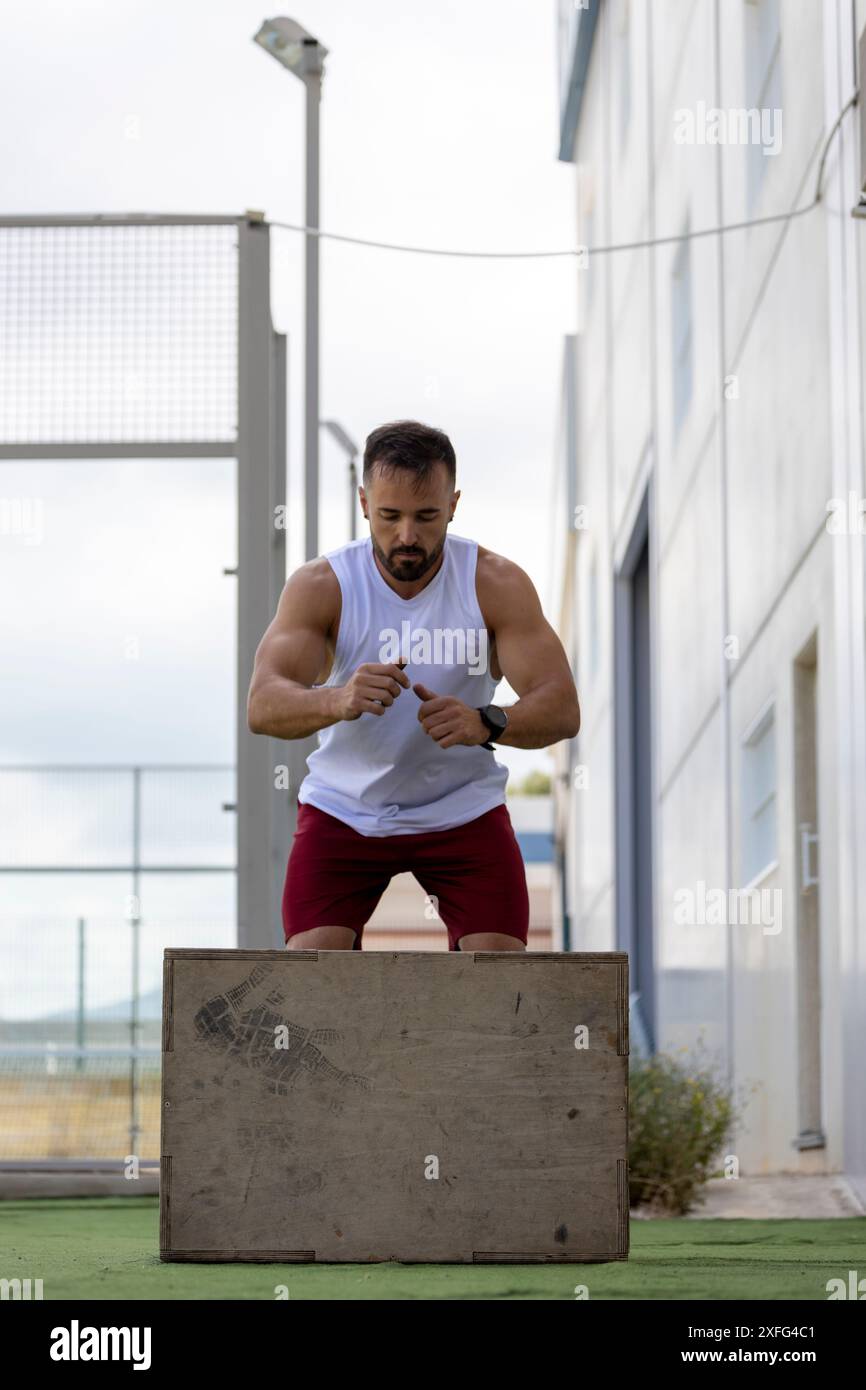 Man doing CrossFit jumping onto a box outdoors Stock Photo - Alamy
