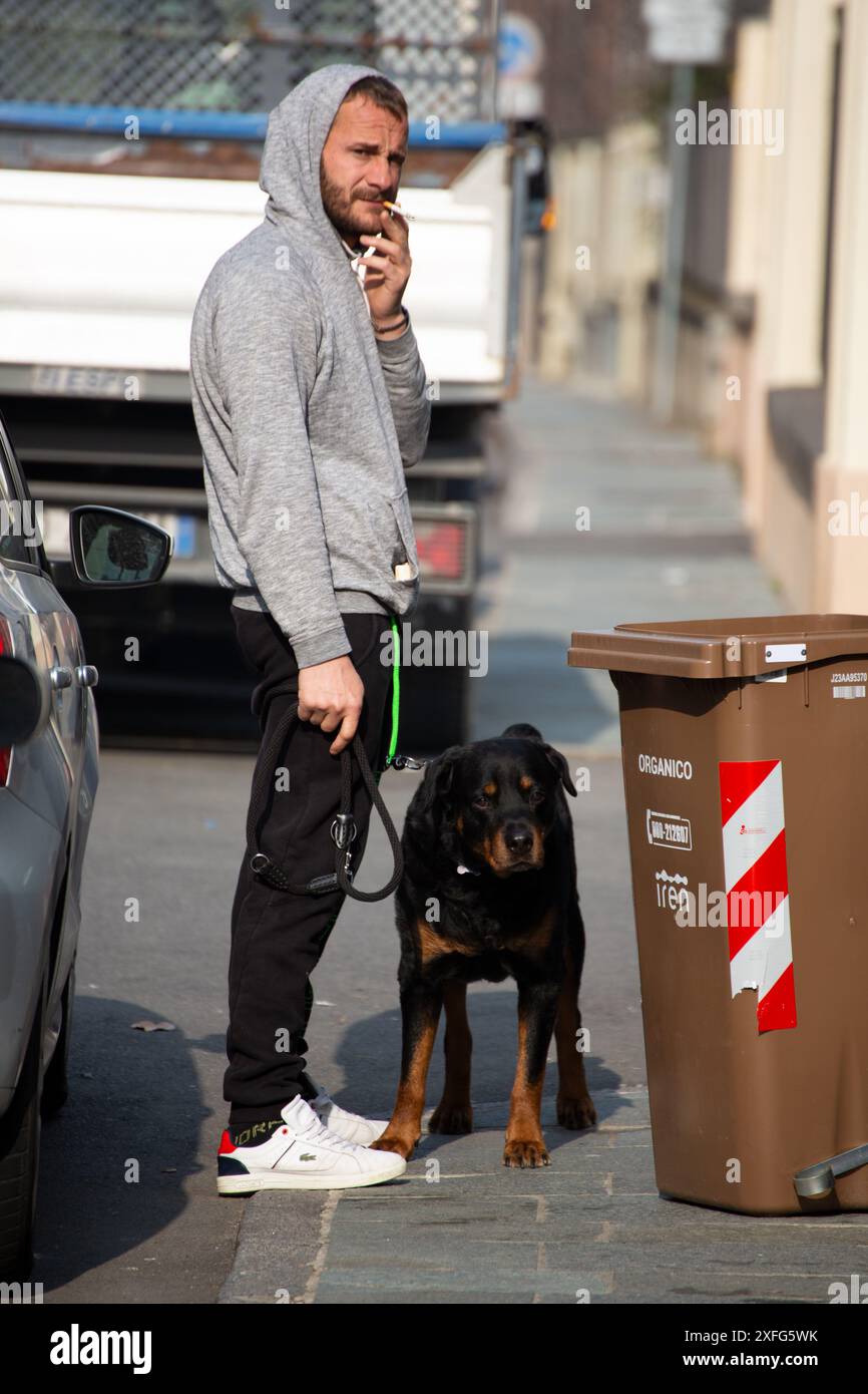 Aggressive man walking his guard dog on leash Stock Photo - Alamy