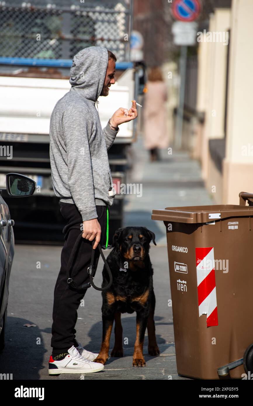 Aggressive man walking his guard dog on leash Stock Photo - Alamy