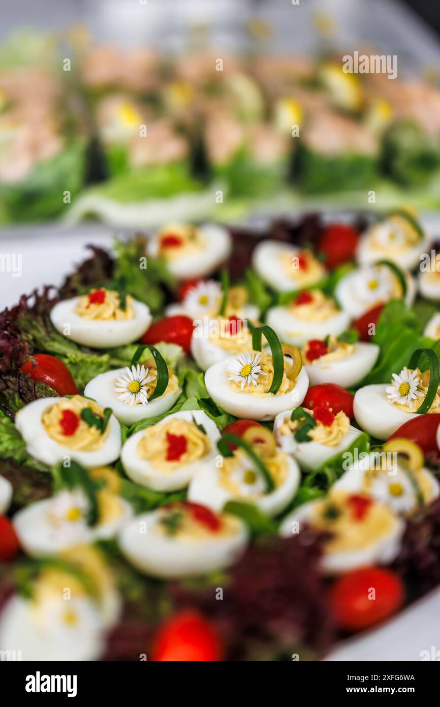 Deviled egg appetizer on a plate decorated with a daisy edible flowers ...