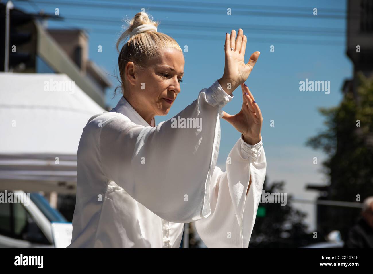 A serene Tai Chi master in a flowing white suit gracefully performs on ...