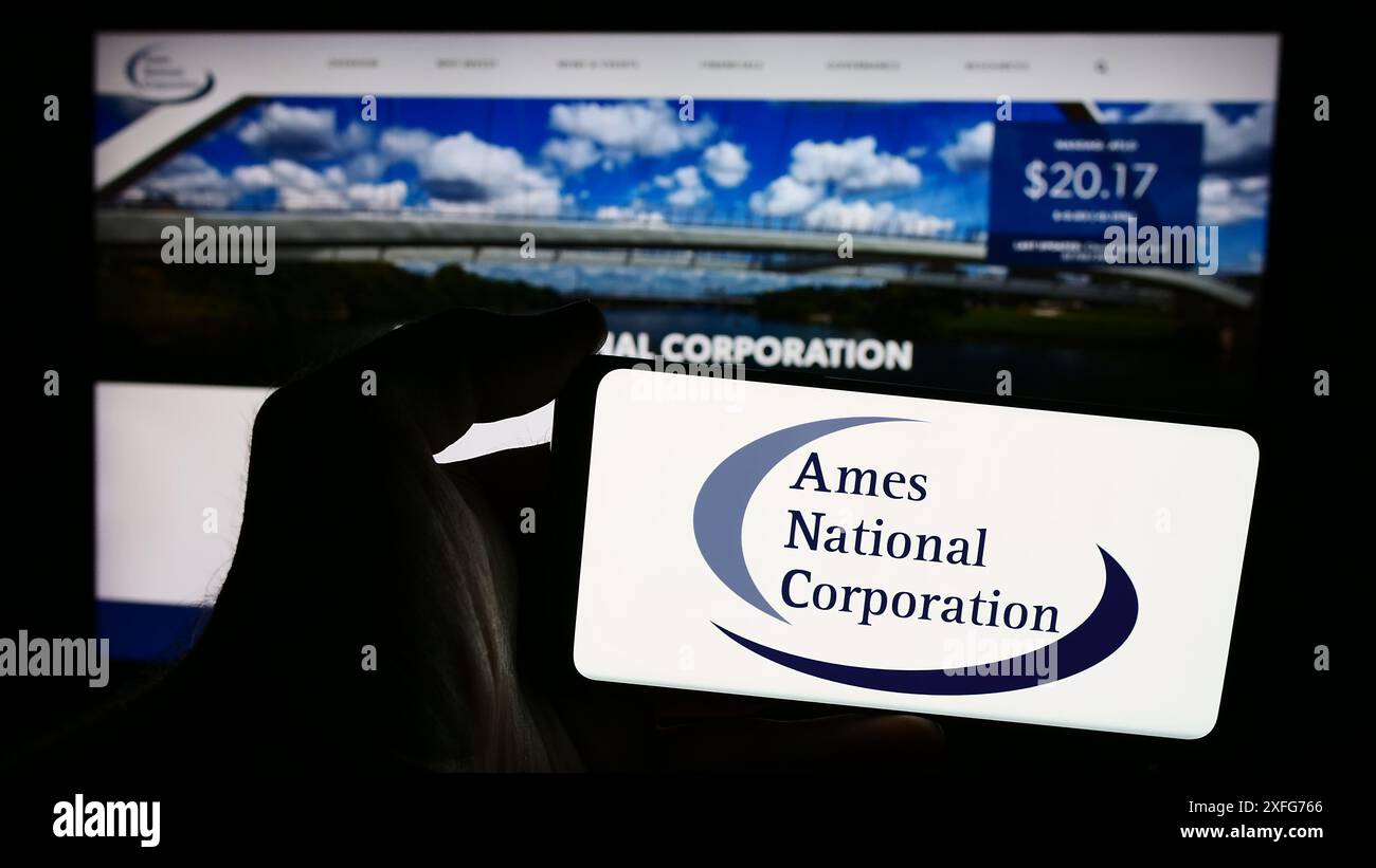 Person holding mobile phone with logo of US financial services company ...