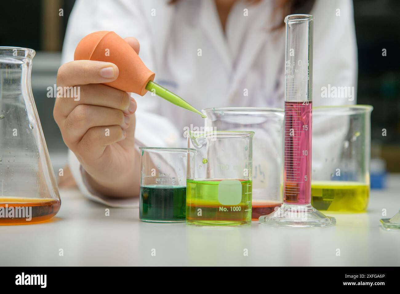 girl scientist loads liquid sample into test tube with plastic pipette ...