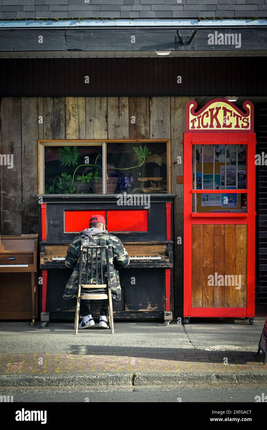 Man playing outdoor community piano, Duncan, Vancouver Island, British ...