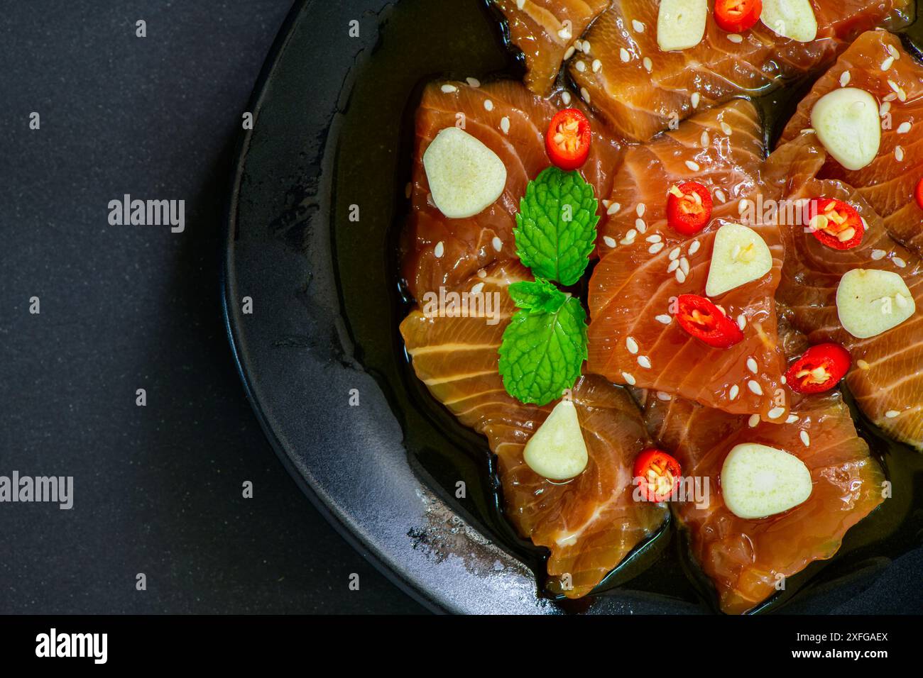 Top view of Pickled Salmon with Soy Sauce, chilli and garlic on stone ...