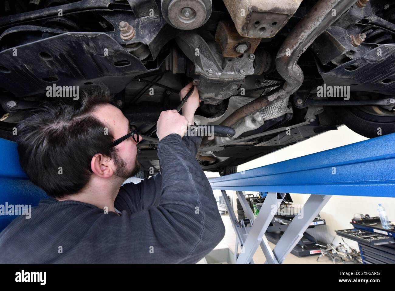 automotive mechanic works on the car to fix a problem automotive ...
