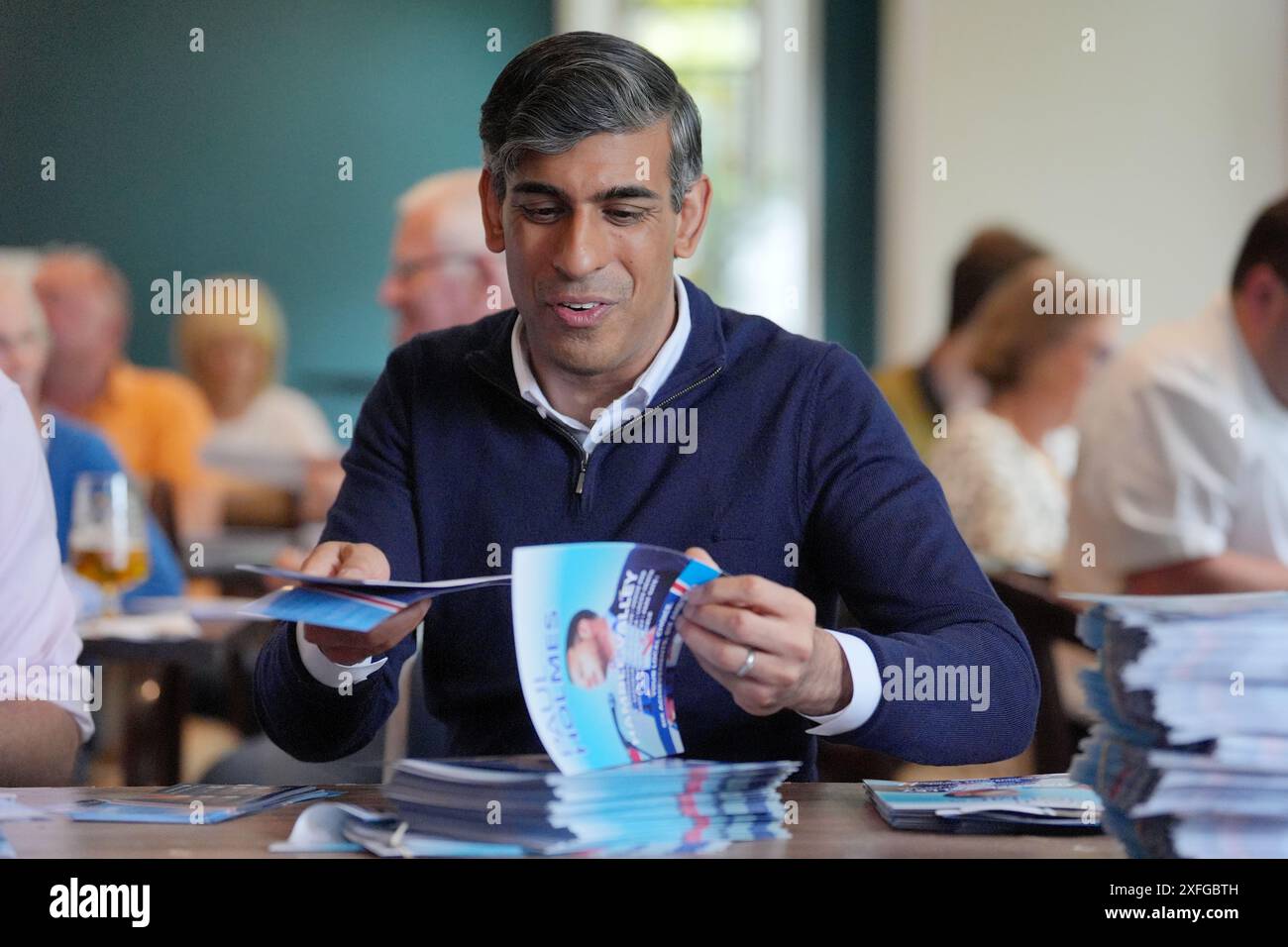 Prime Minister Rishi Sunak holds the Conservative Party's leaflets as ...
