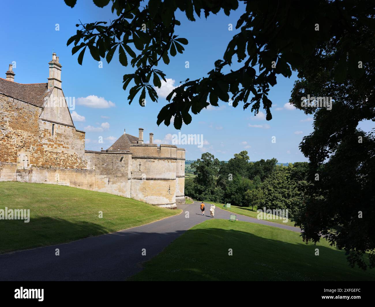 A couple of visitors beside the twin round towers at Rockingham castle ...