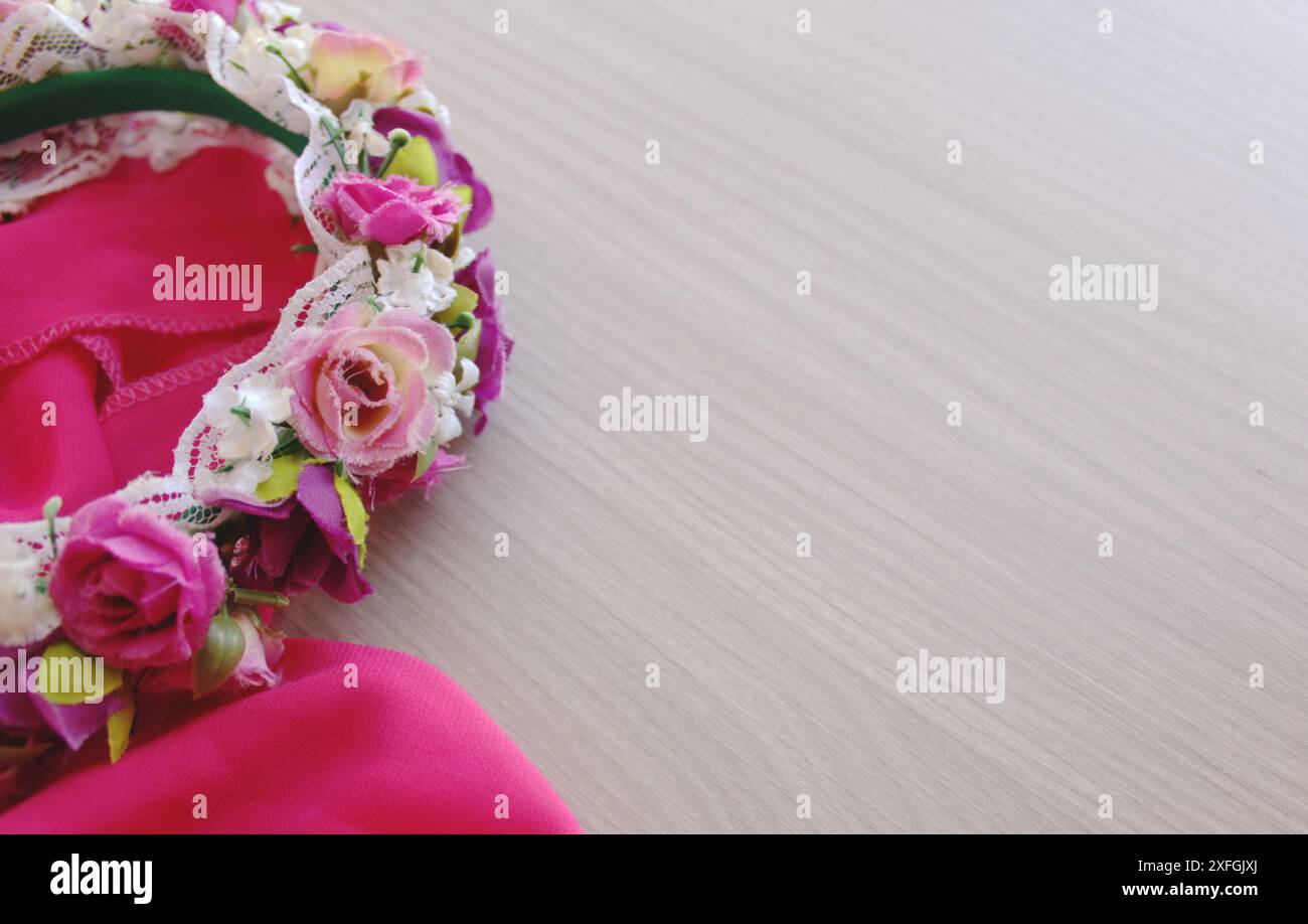 Pink fabric and floral tiara on wood background with copy space ...