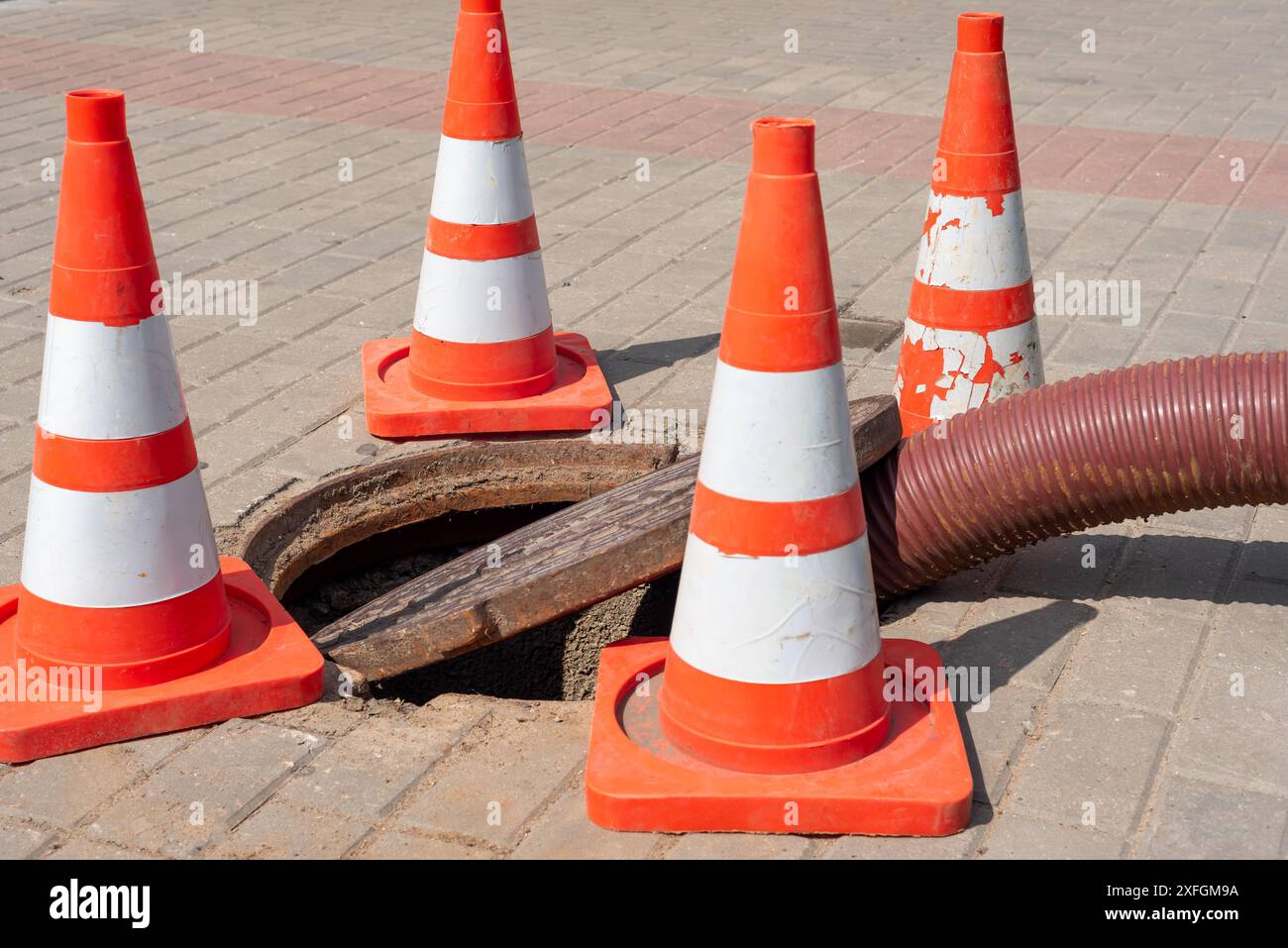 An open sewer manhole on a city street. Repair of city sewerage and ...