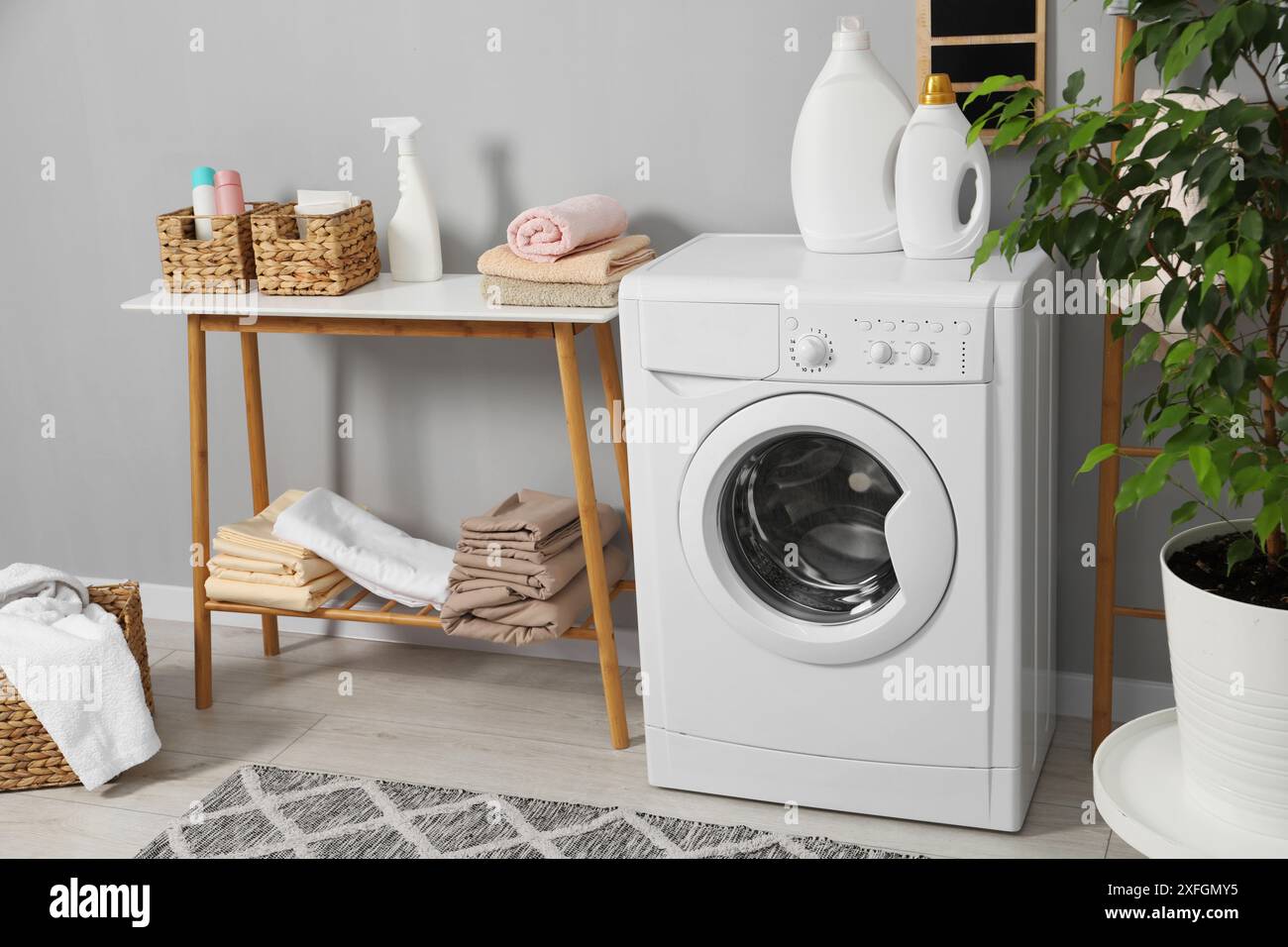 Washing machine, storage bench, detergents, laundry and houseplant ...