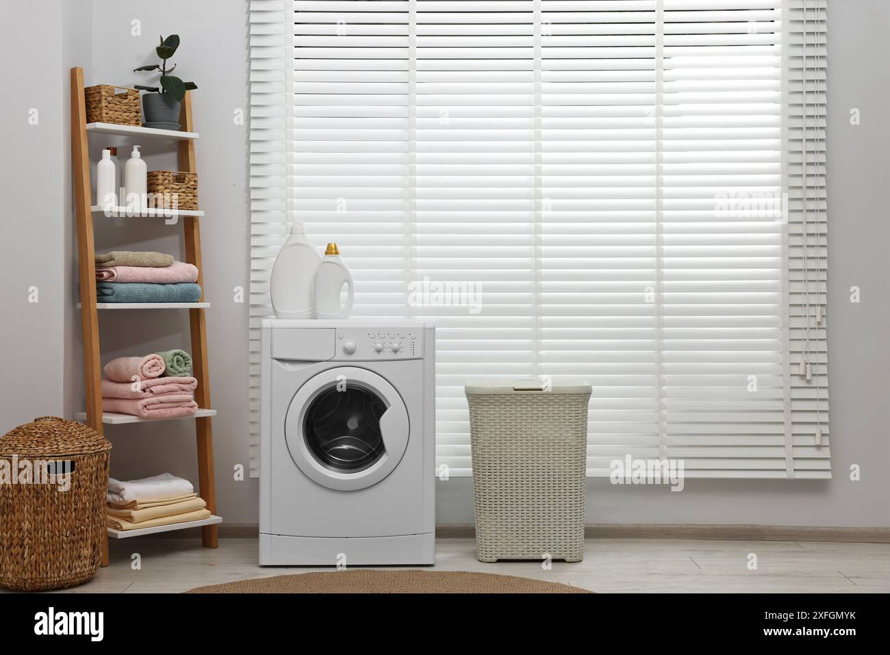 Washing machine, detergents, towels and baskets in laundry room Stock ...