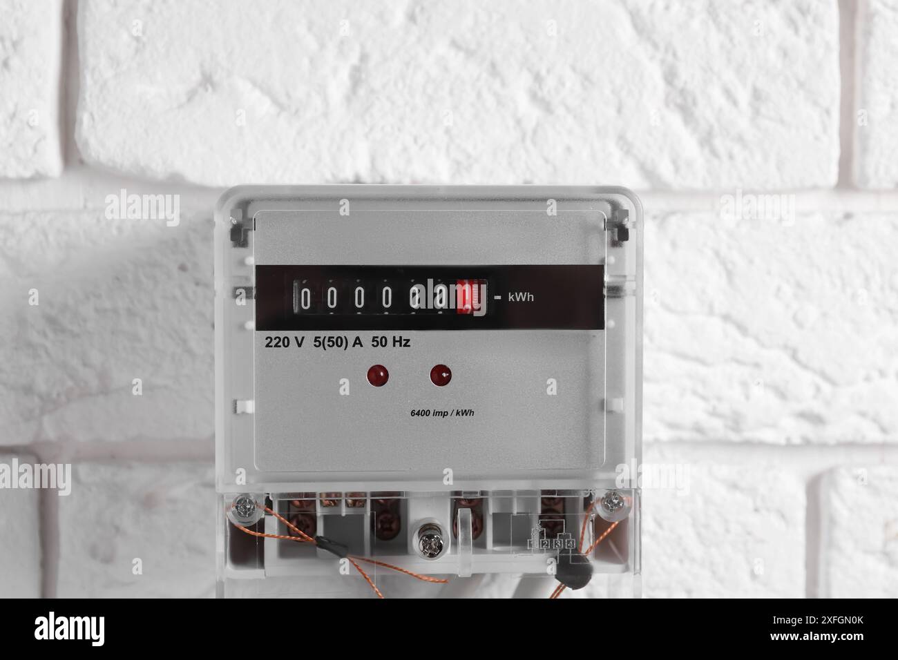 Electric meter on white brick wall. Energy measuring device Stock Photo ...