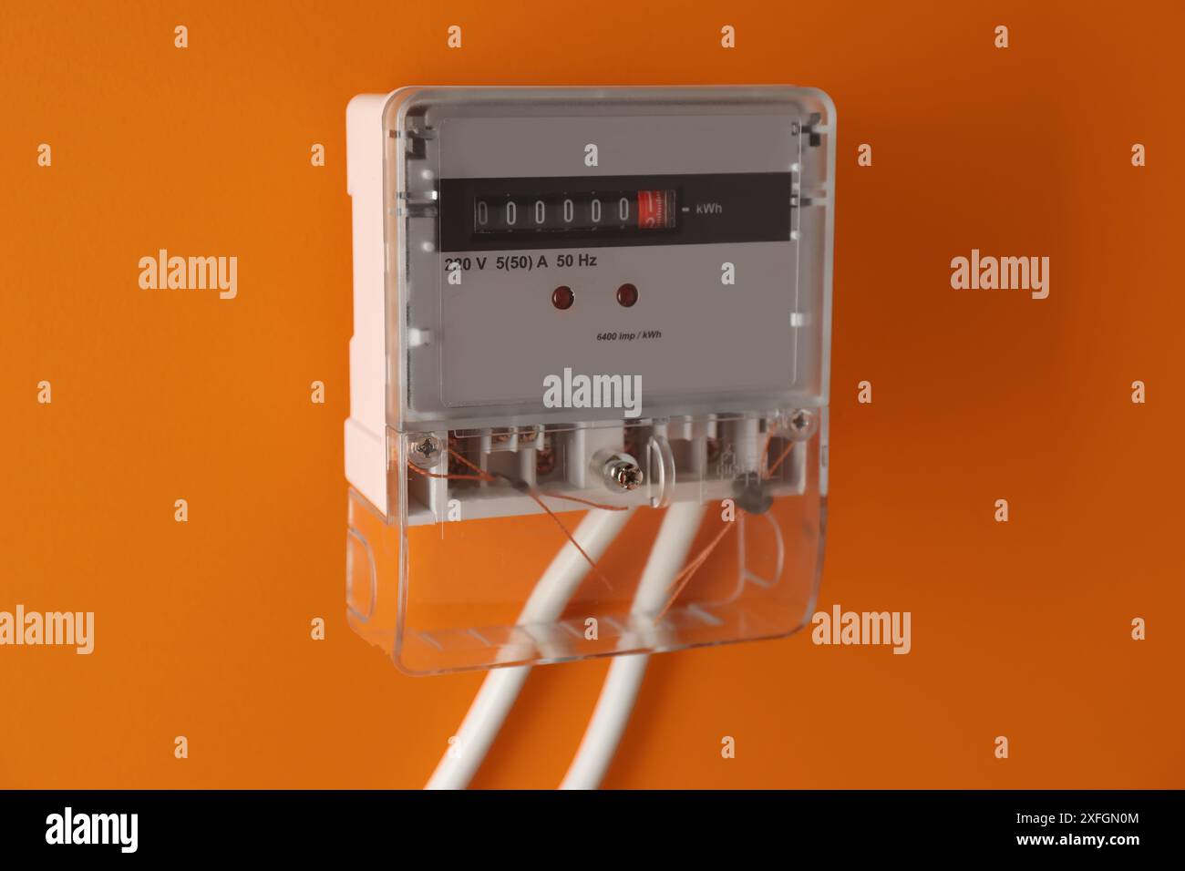 Electric meter on orange background. Energy measuring device Stock ...