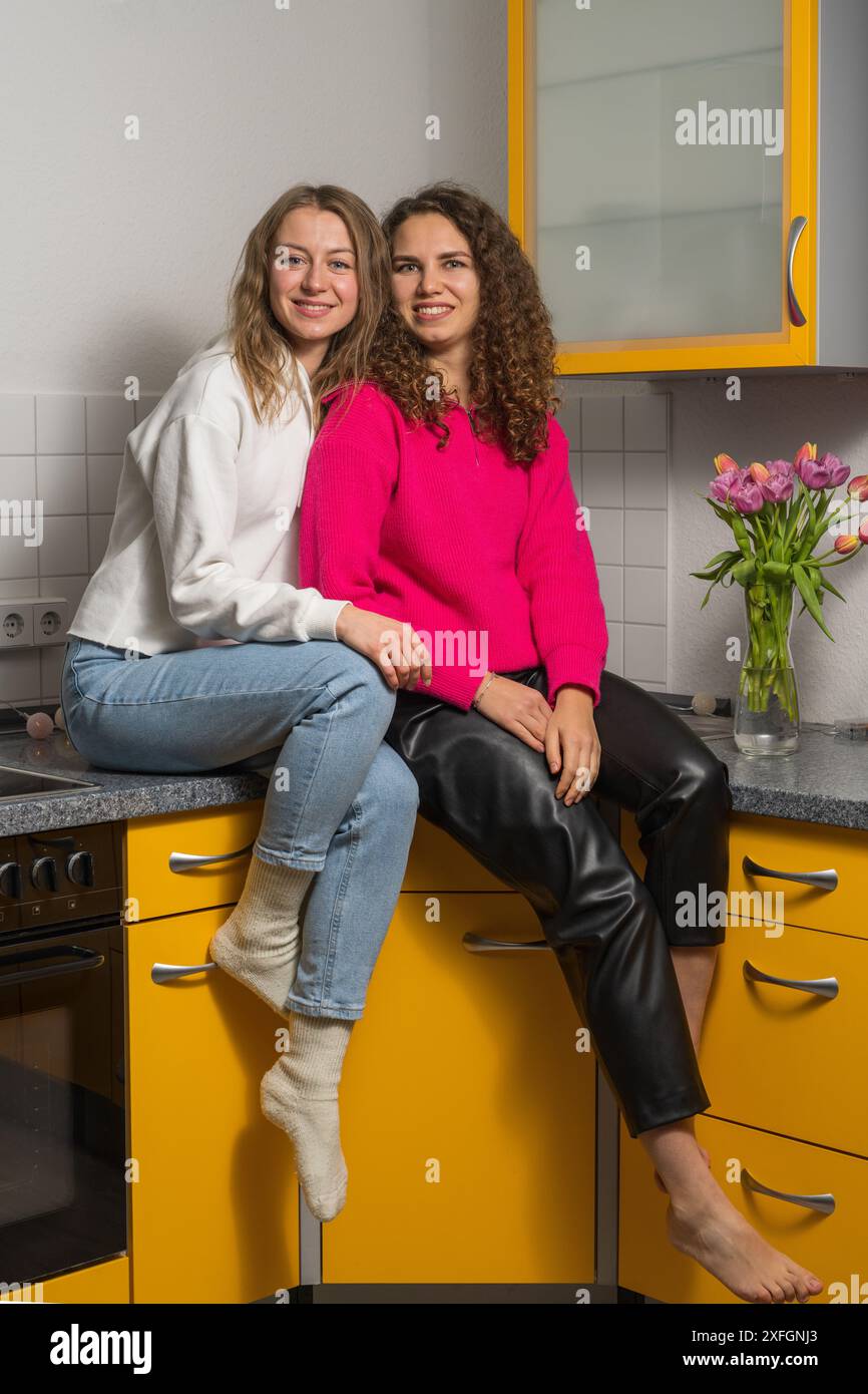 Two happy, young Caucasian women relaxing at home, having fun, sitting ...