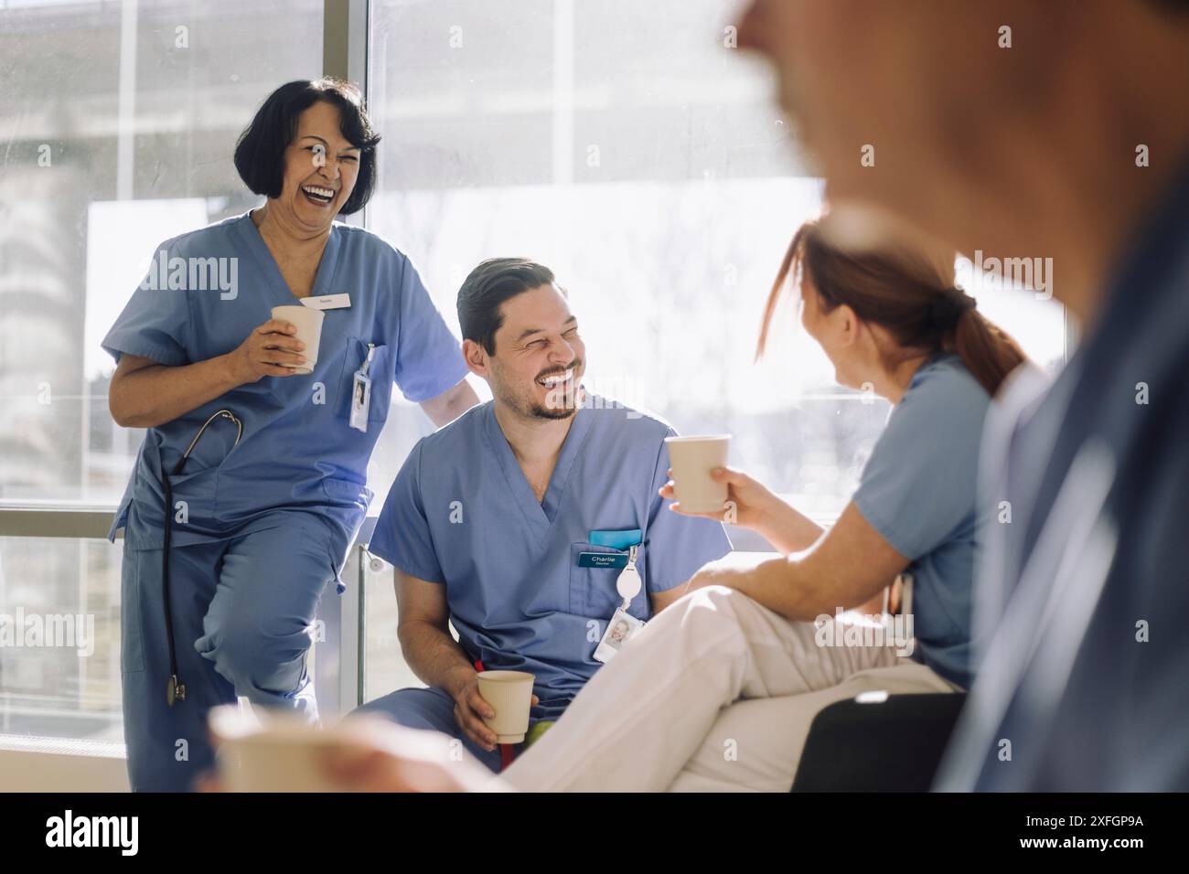 Happy team of male and female doctors enjoying during coffee break at ... Happy team of male and female doctors enjoying during coffee break at ...