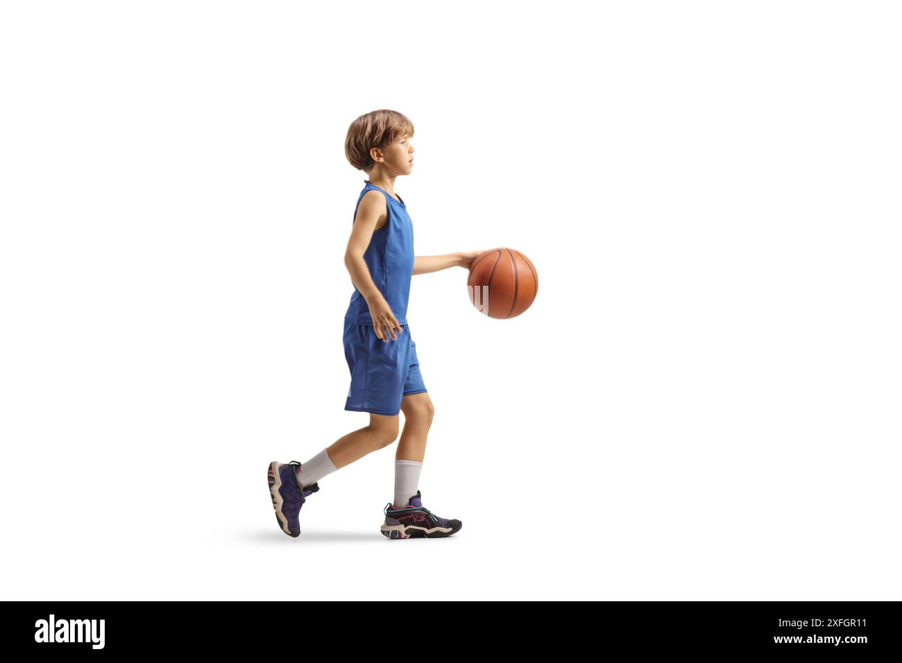 Full length profile of a boy walking with a basketball isolated on ...