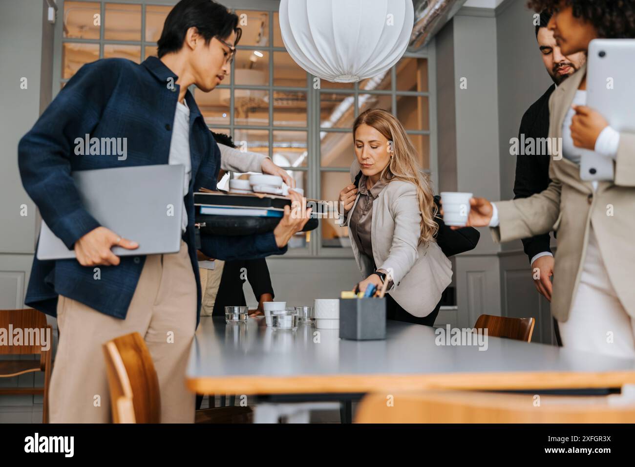Busy business professionals picking up office stuff from table in ...