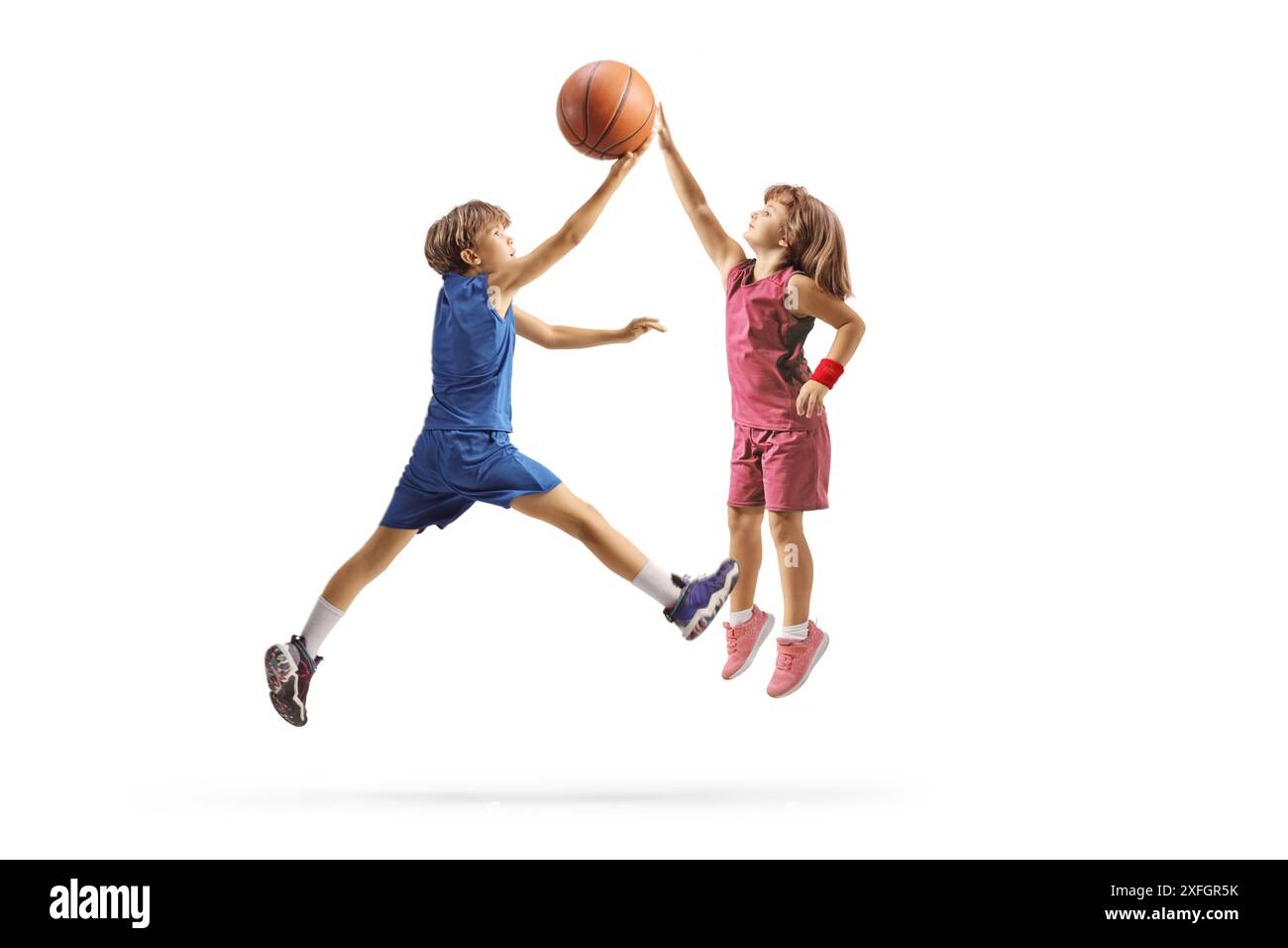 Full length profile shot of a boy and girl jumping with basketball ...