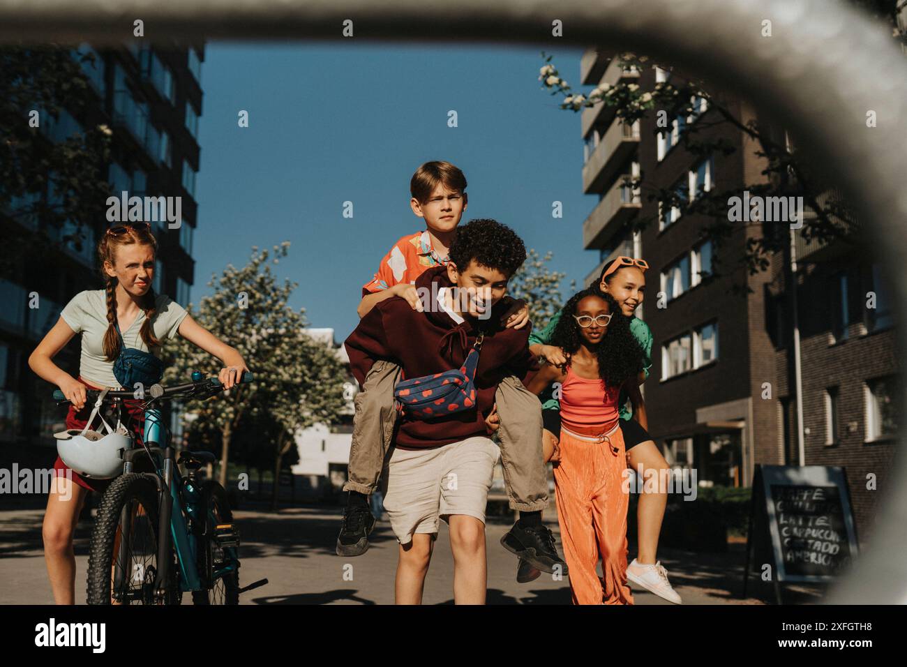 Group of playful friends walking on street Stock Photo - Alamy