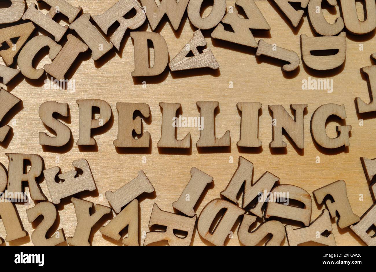 Spelling, word in wooden alphabet letters surrounded by random block ...