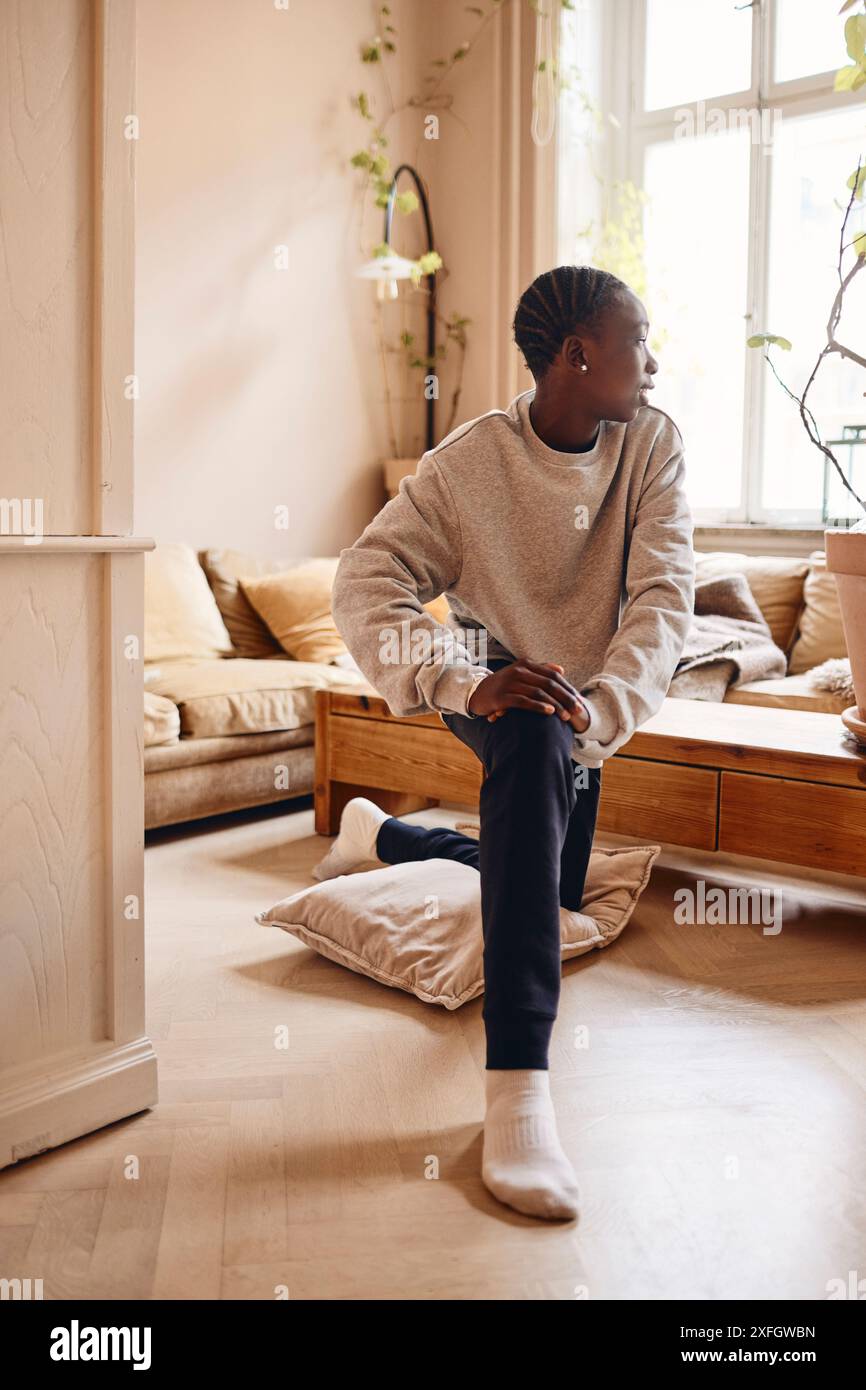 Teenage boy stretching in living room at home Stock Photo - Alamy