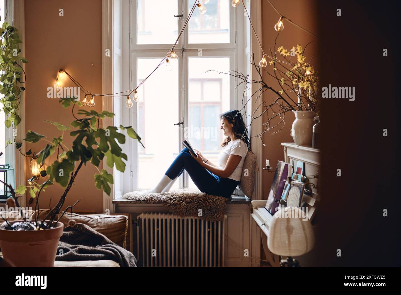 Young woman sitting on window sill hi-res stock photography and images ...