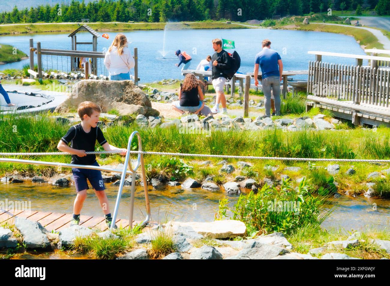 Small boy sailing on a wooden raft on a water playground at the top of ...