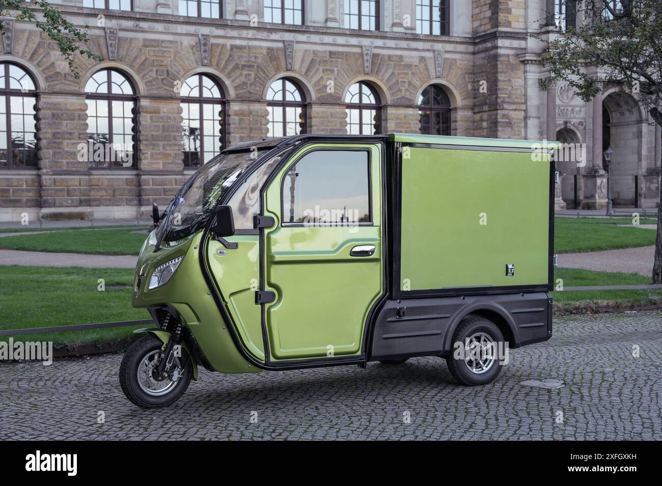 Small green electric car near the castle Stock Photo - Alamy