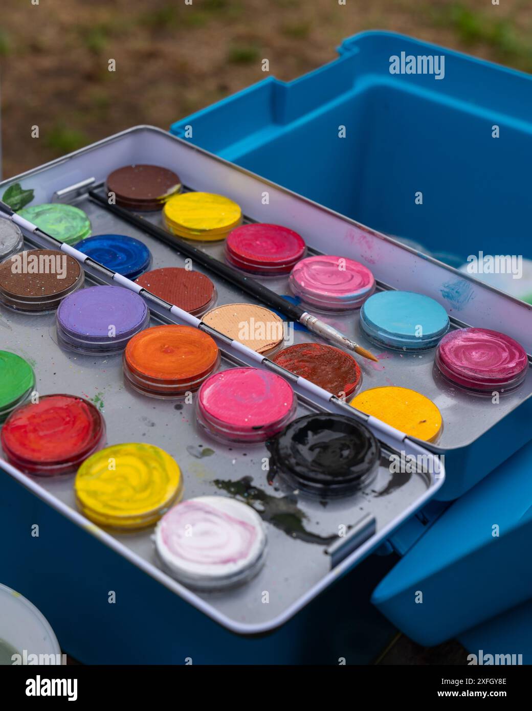 Colourful paint boxes and tubes with paints on a table. Paints and ...