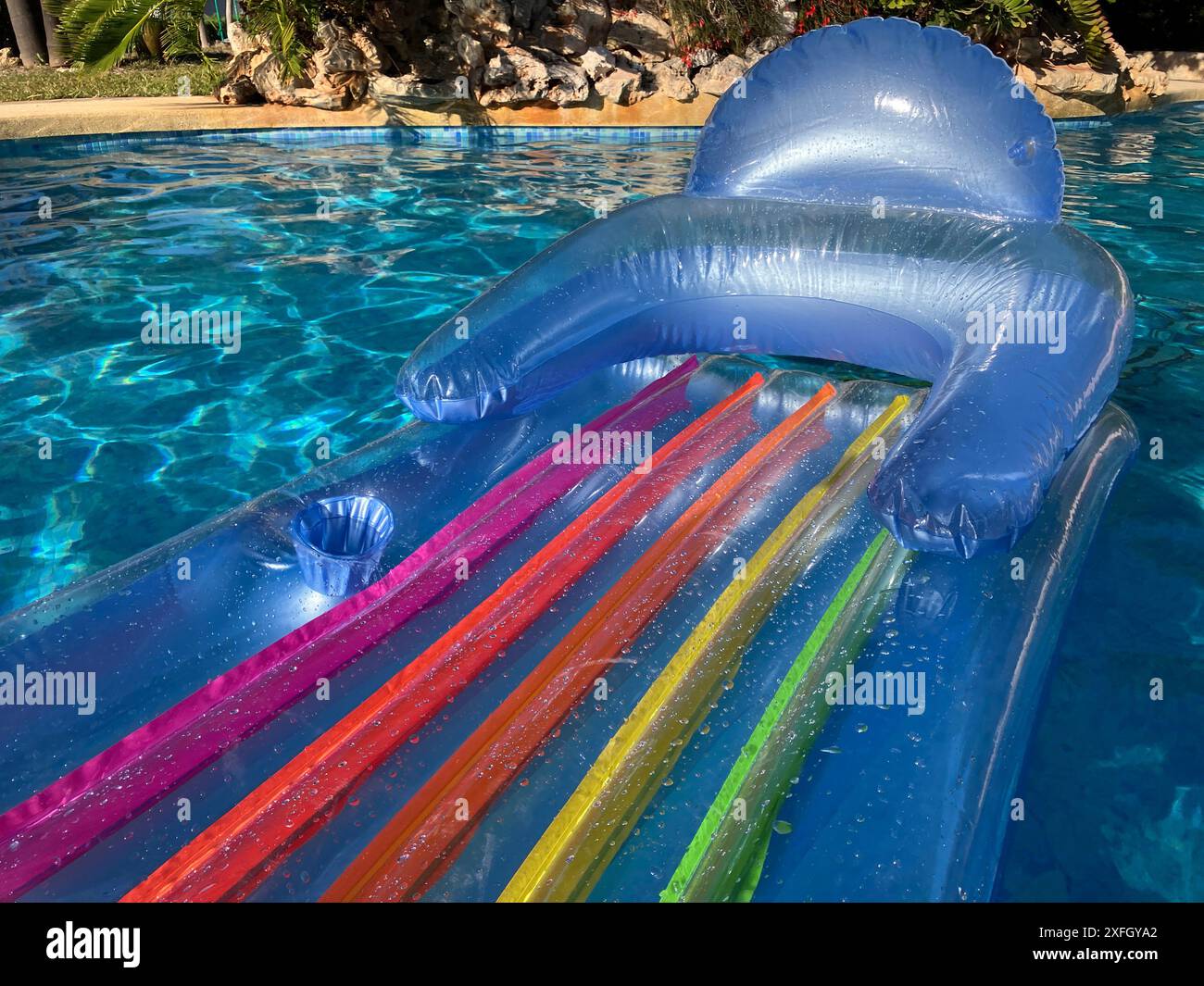 Bright and colourful lilo floating in a swimming pool, summer vibes ...