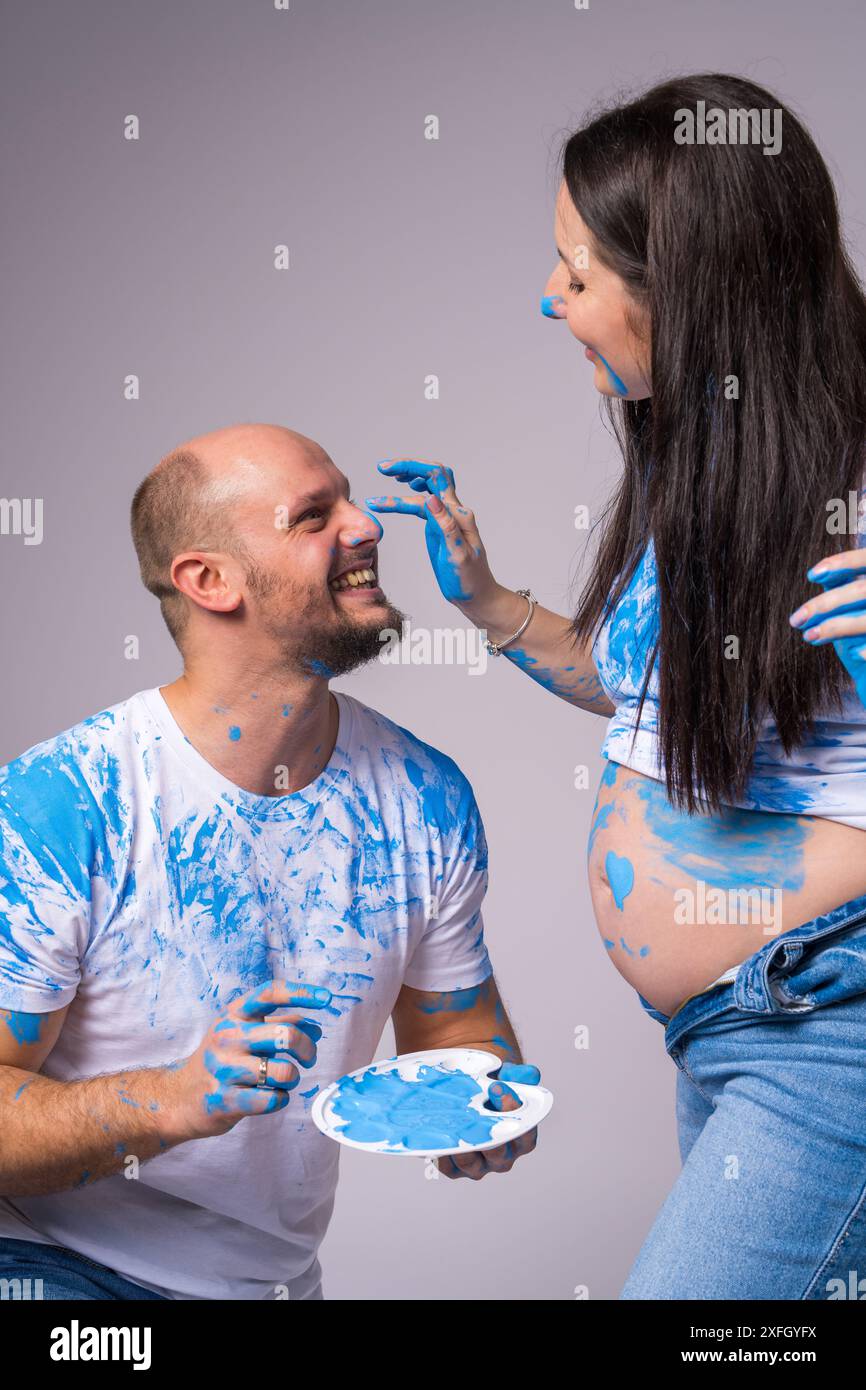 Happy couple at a gender reveal party. A man and a pregnant woman are ...