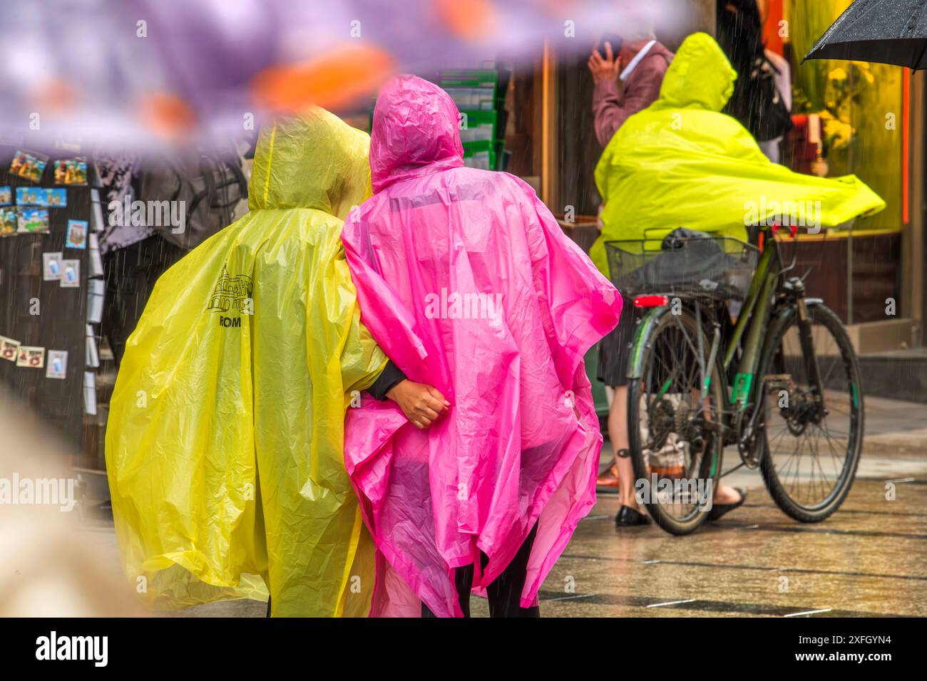 Frauen mit Regenponchos in der Münchner Fußgängerzone, Regenwetter im ...