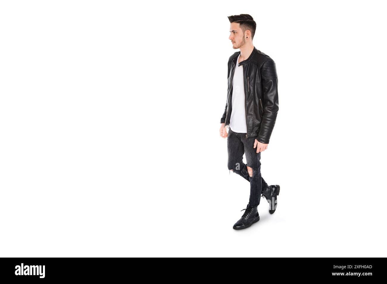 young man walk in studio isolated in black clothes with leather jacket ...