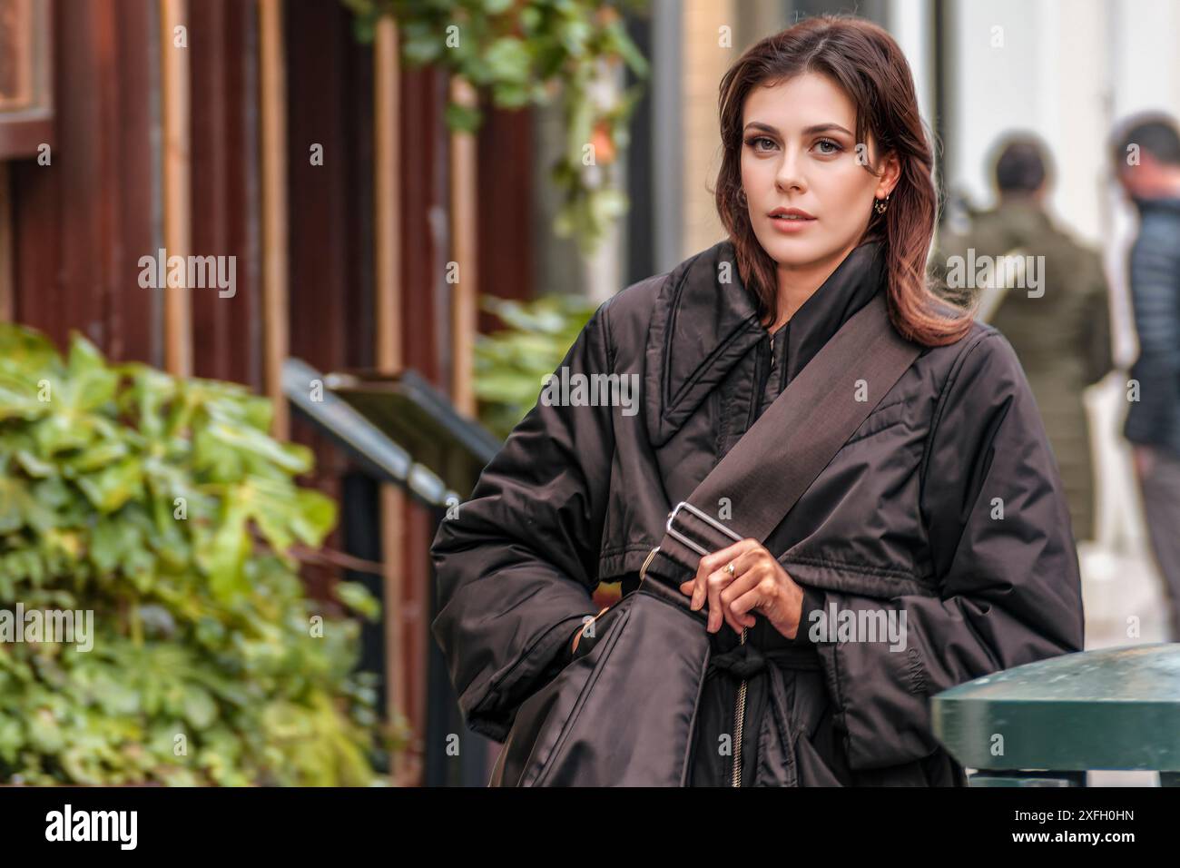 Street portrait of Dublin’s woman. A young woman in a black winter coat ...
