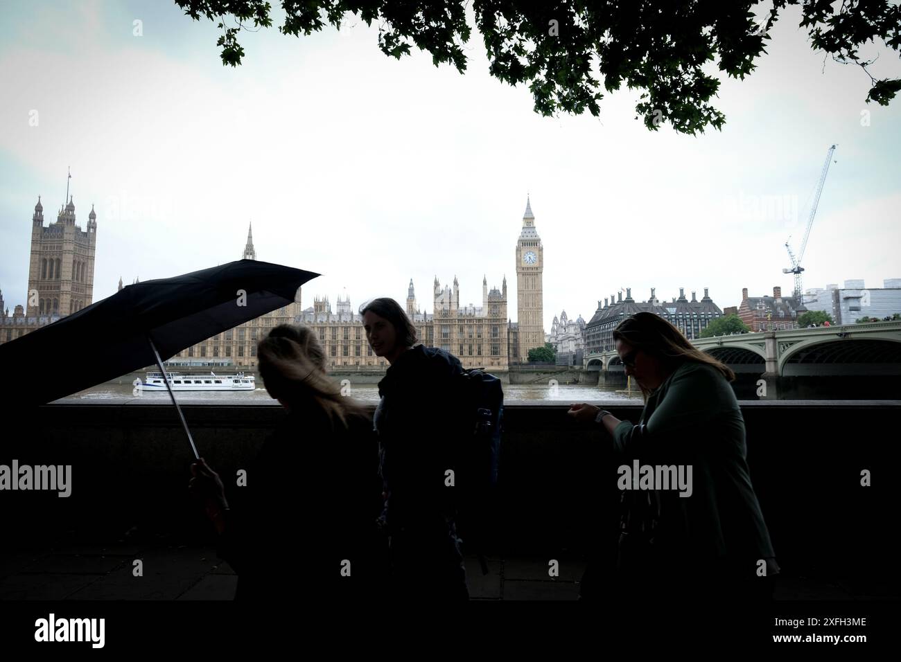 London, United Kingdom. 3rd July, 2024. People walk with umbrellas in ...