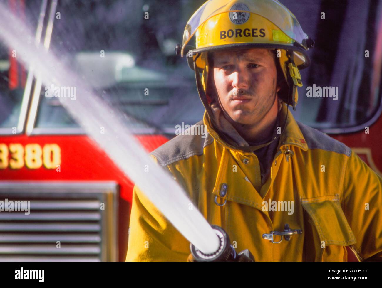 Fireman mans a hose to extinguish a fire, USA 1997 Stock Photo - Alamy