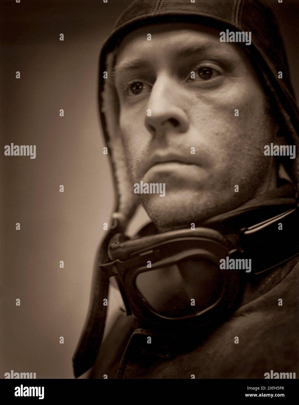 Head and shoulders portrait of mid-adult man wearing vintage pilot ...