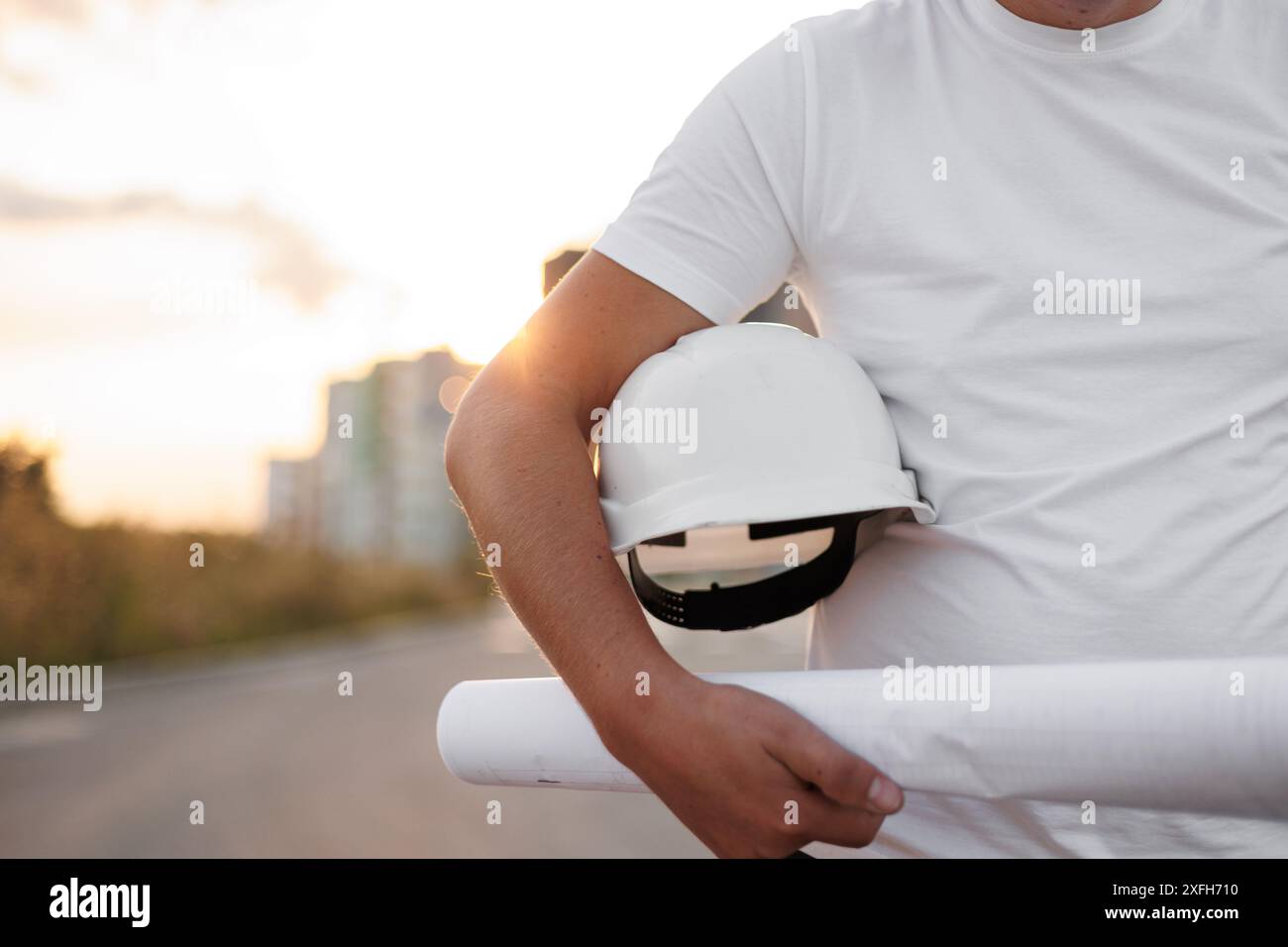 Unrecognisable male civil engineer holds protective white hard hat and ...