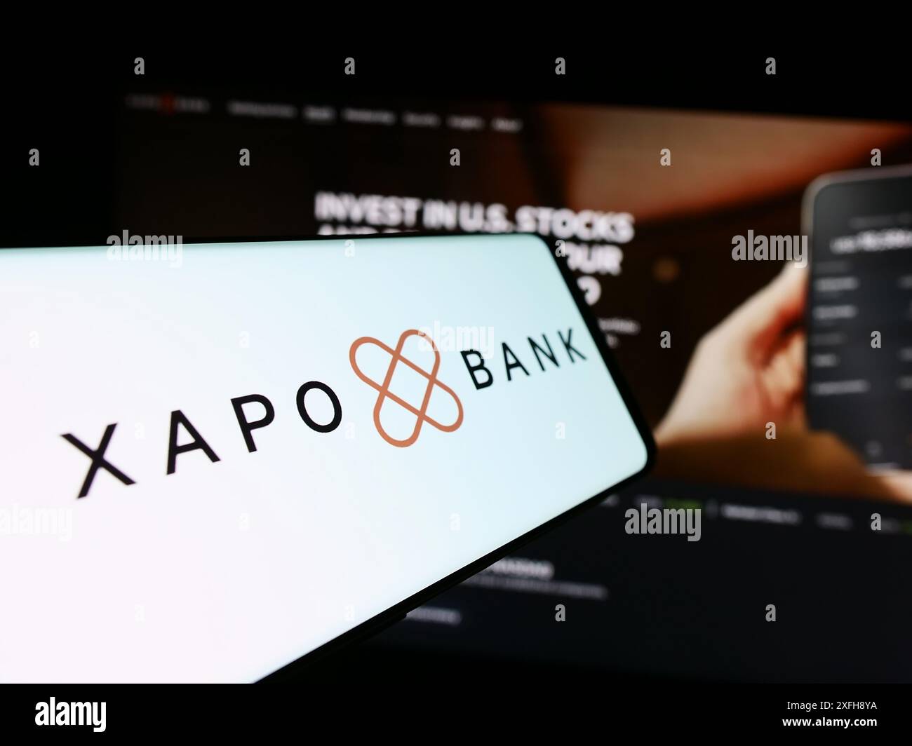 Mobile phone with logo of crypto banking company Xapo Holdings Limited in front of business ...